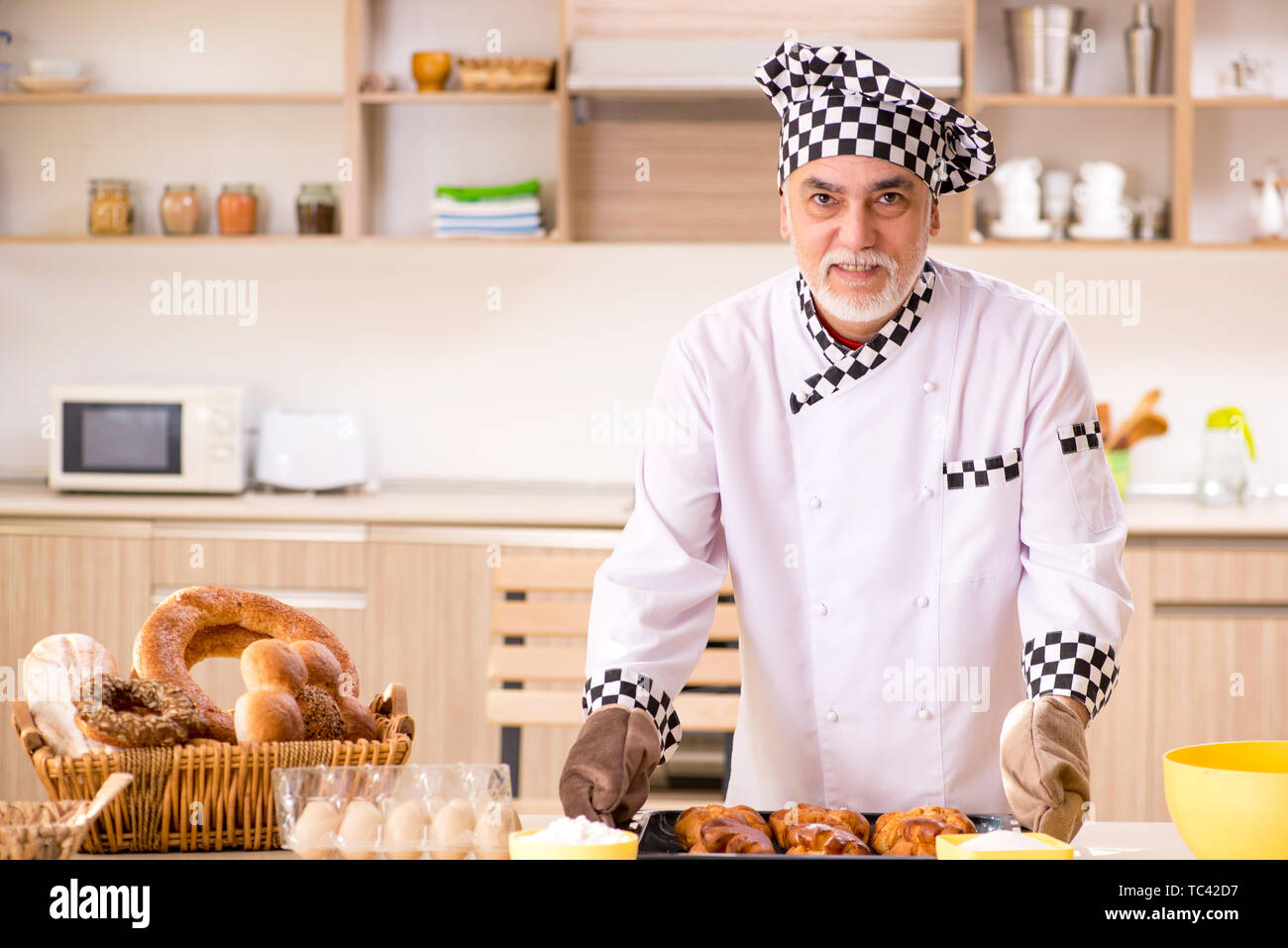 Old male baker working in the kitchen Stock Photo - Alamy