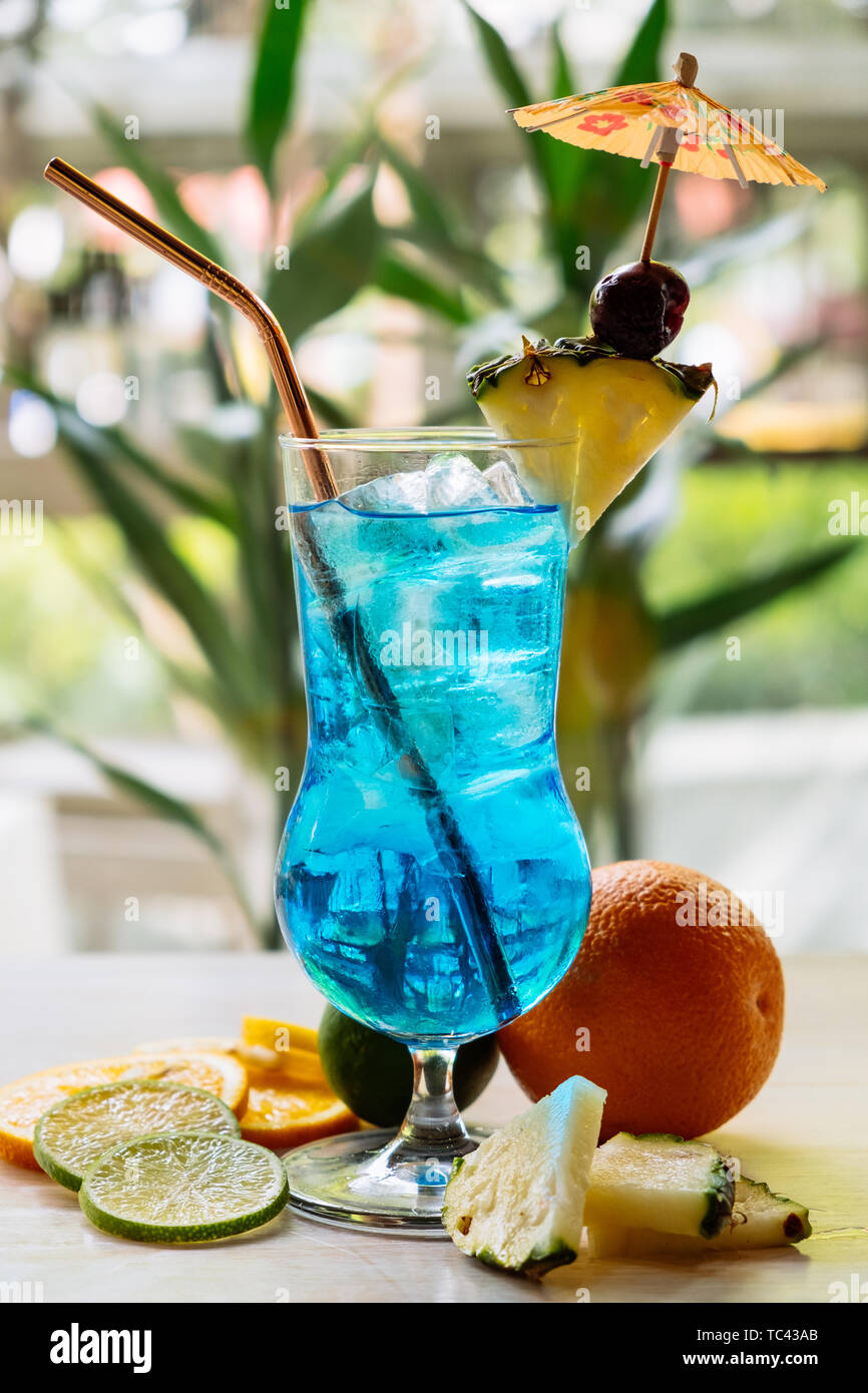 close up of a colorful fancy trendy cocktail garnished with fresh ...