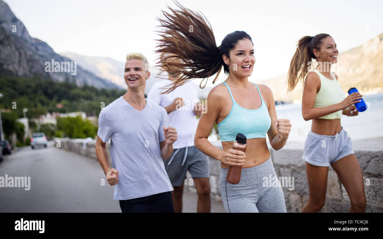 Outdoor portrait of group of friends running and jogging in nature ...