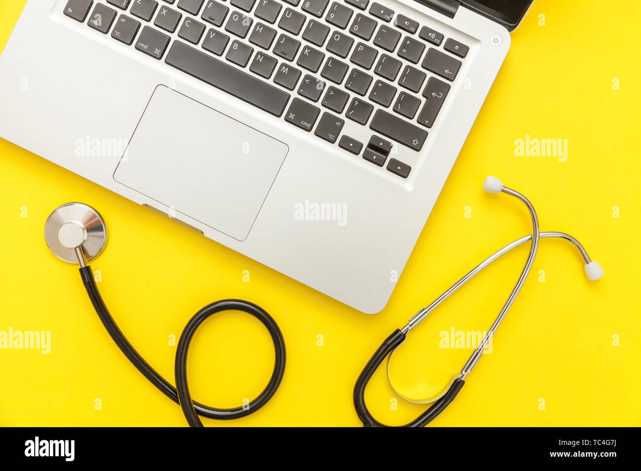 Stethoscope keyboard laptop computer isolated on yellow background ...