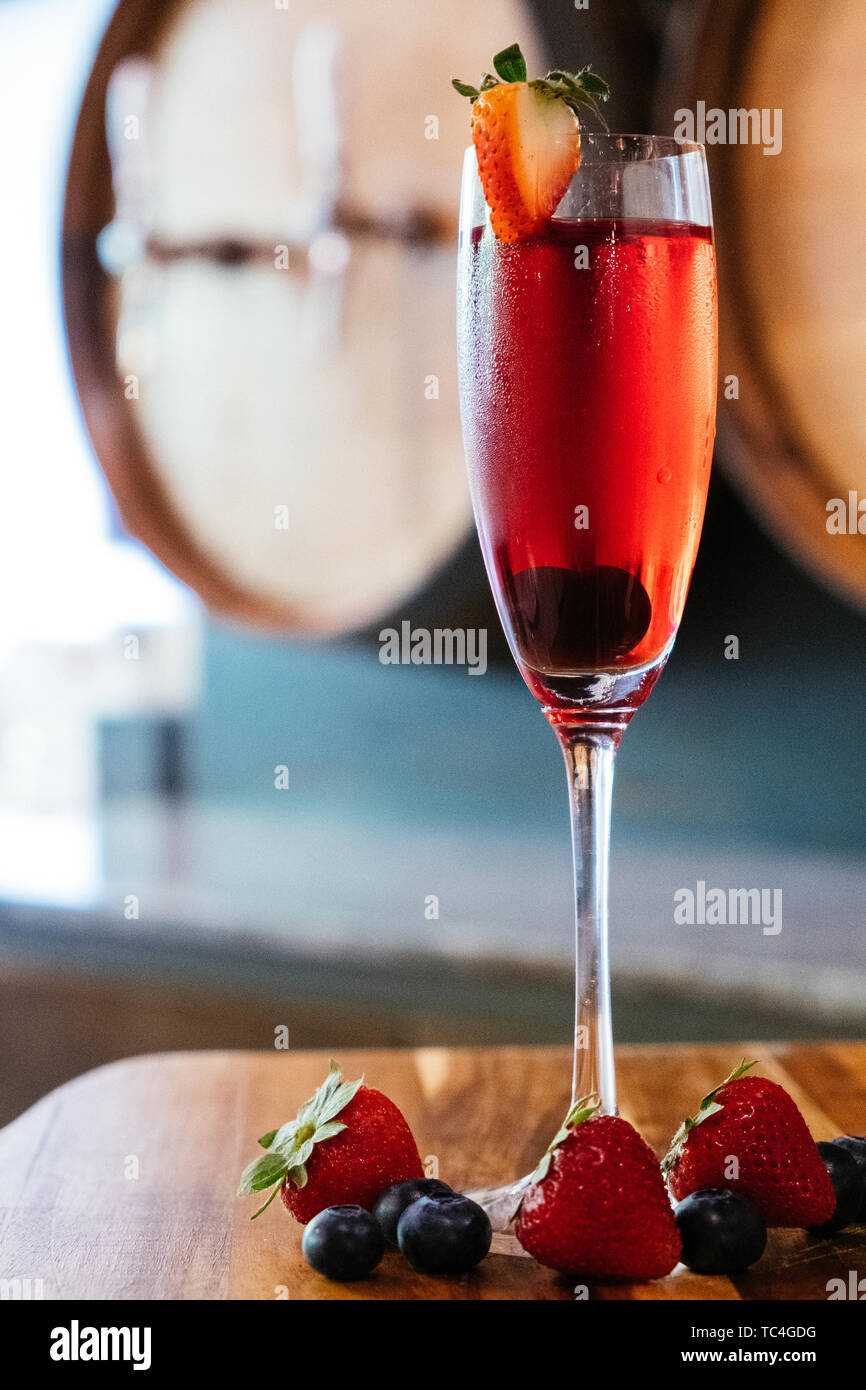 close up of a colorful fancy trendy cocktail garnished with fresh ...