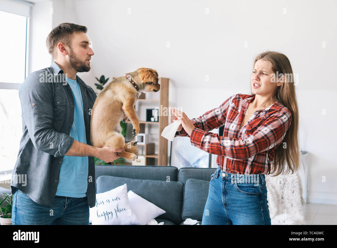 Man with dog and his wife suffering from pet allergy at home Stock ...
