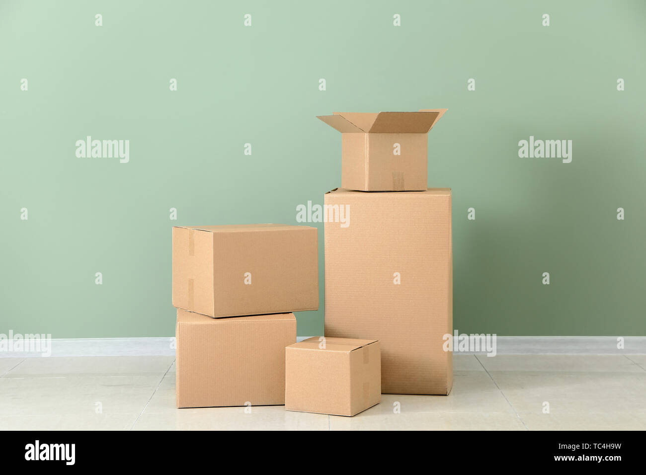 Cardboard boxes near color wall Stock Photo - Alamy