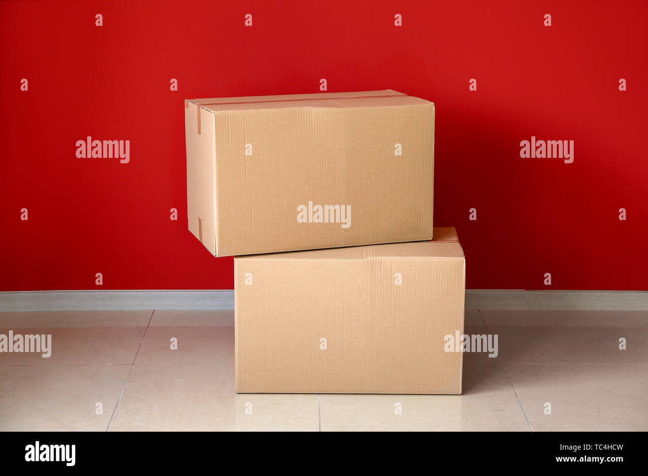 Cardboard boxes near color wall Stock Photo - Alamy