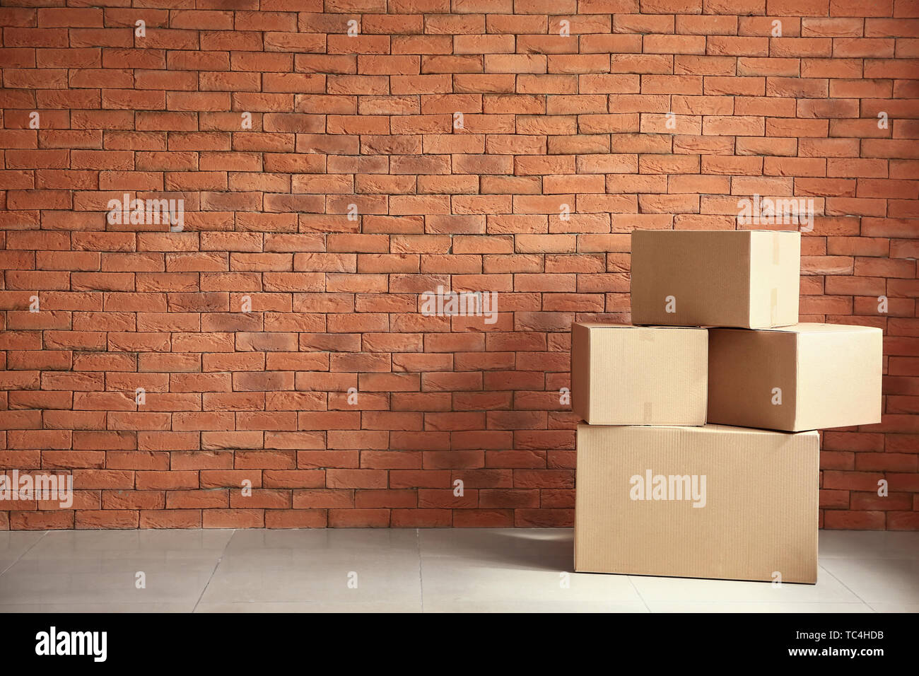 Cardboard boxes near brick wall Stock Photo - Alamy