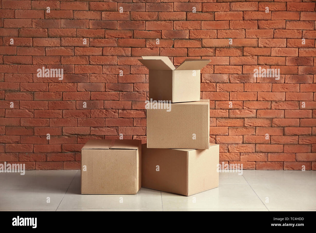 Cardboard boxes near brick wall Stock Photo - Alamy
