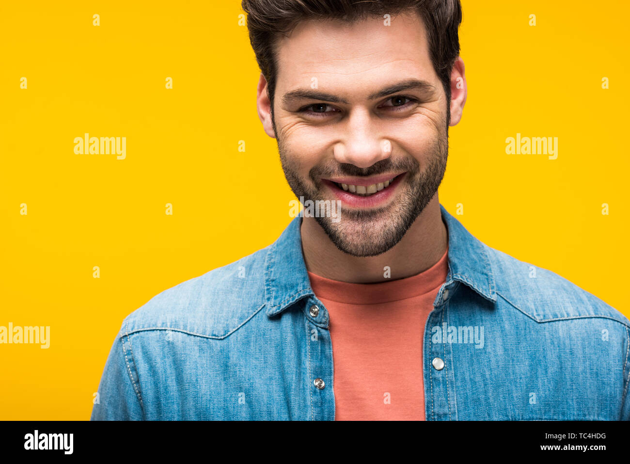 smiling good-looking man looking at camera Isolated On yellow Stock ...