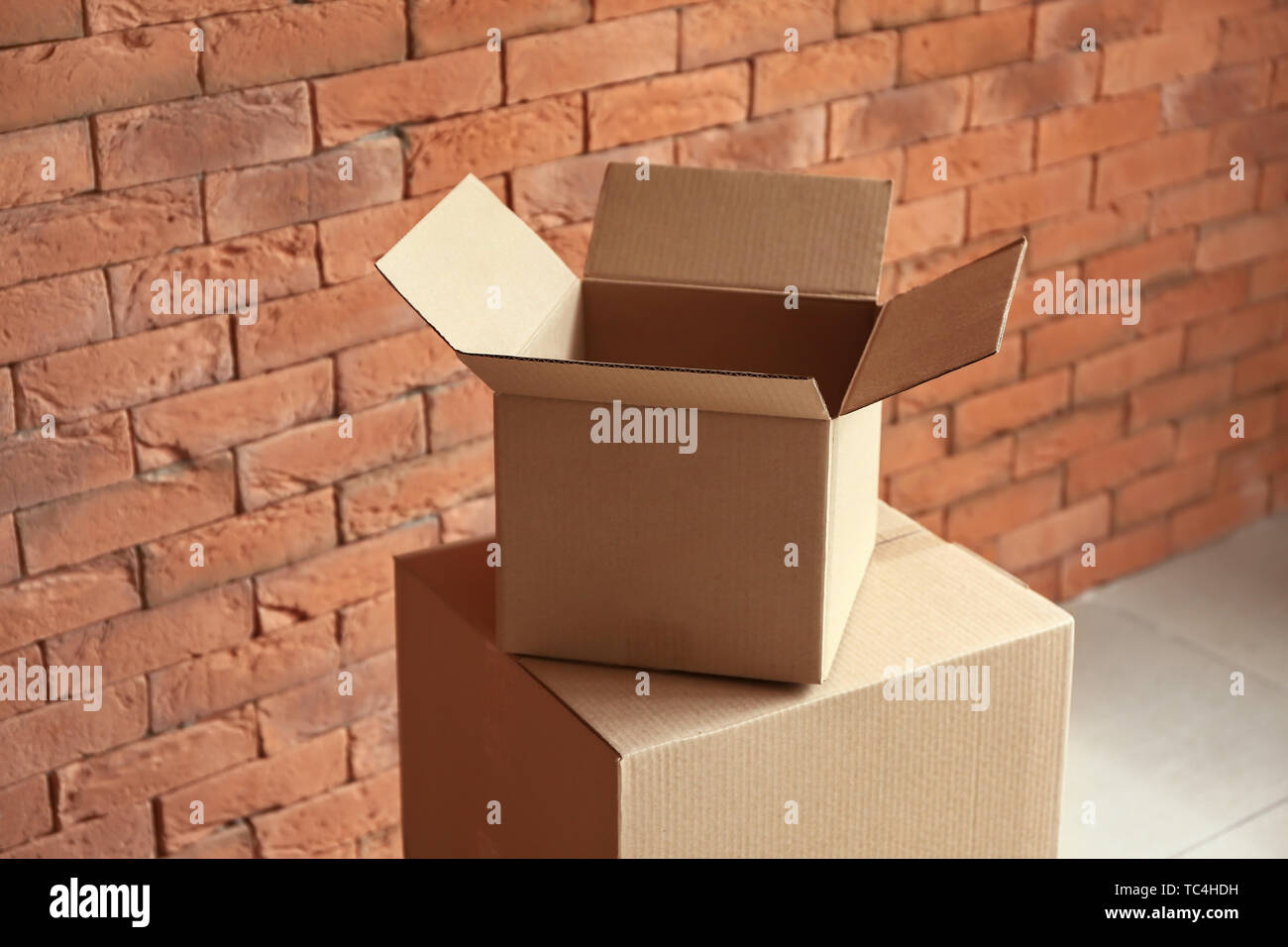 Cardboard boxes near brick wall Stock Photo - Alamy