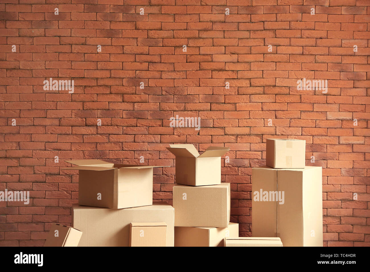 Cardboard boxes near brick wall Stock Photo - Alamy