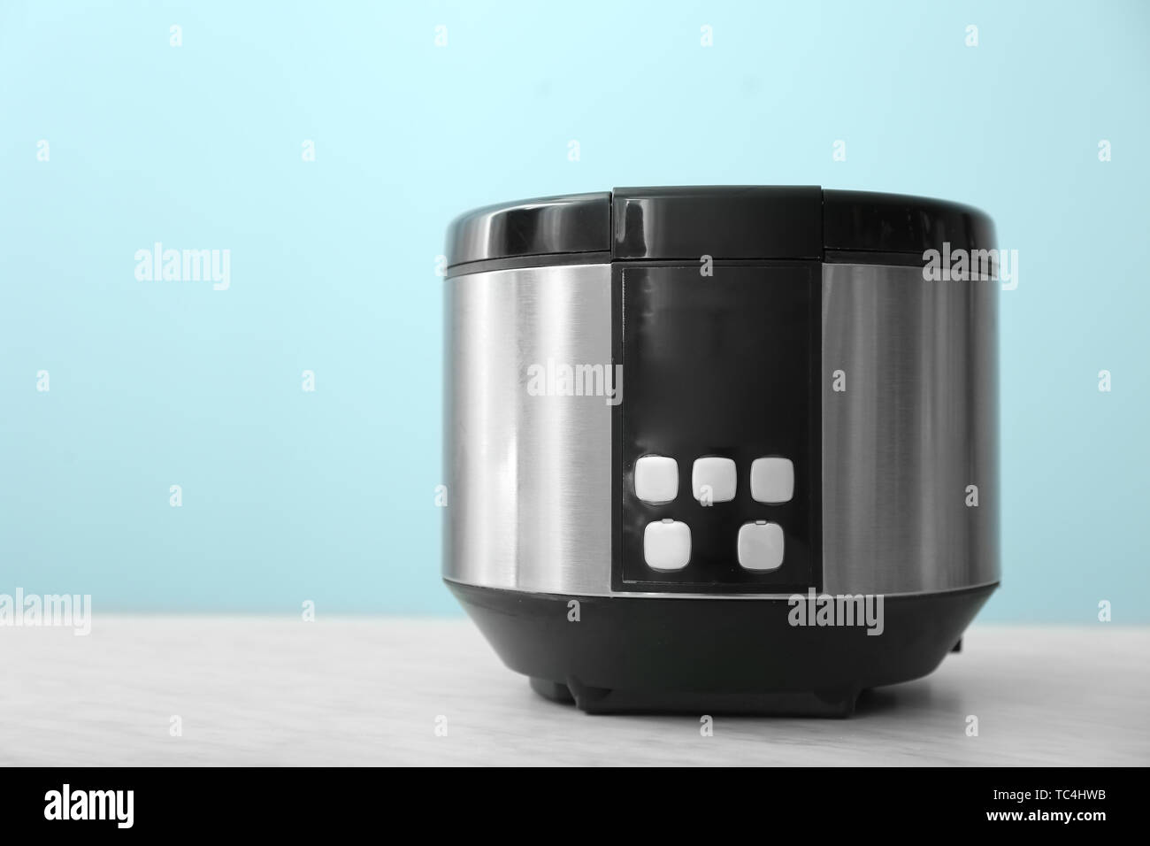 Modern multi cooker on table against color background Stock Photo - Alamy