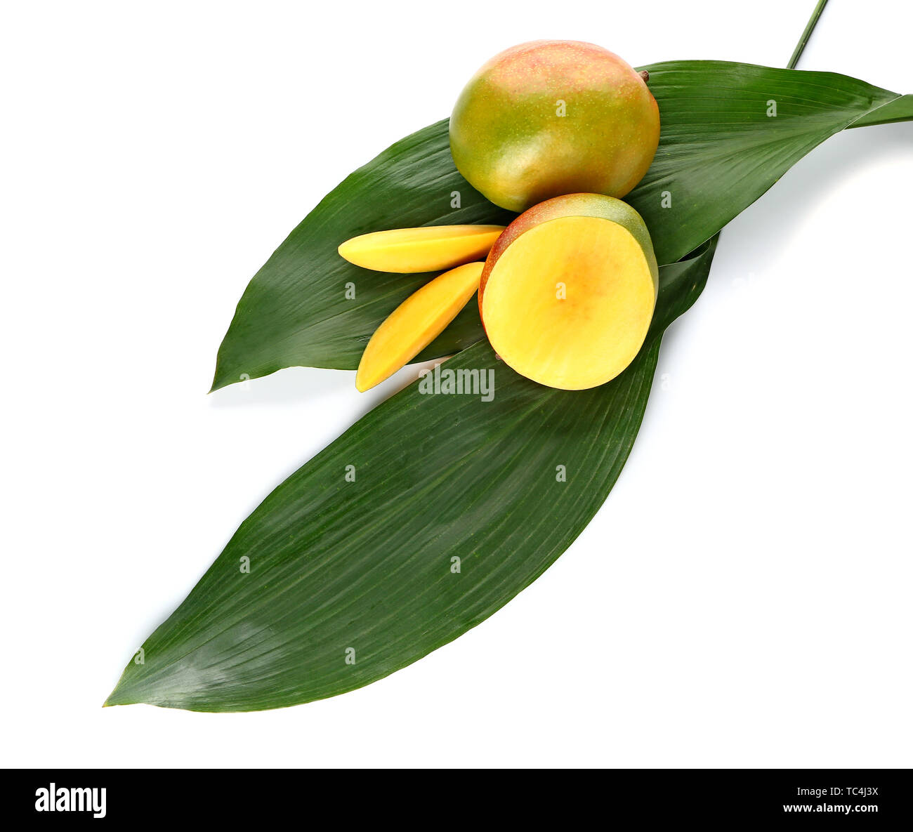 Tasty fresh mango with tropical leaves on white background Stock Photo ...
