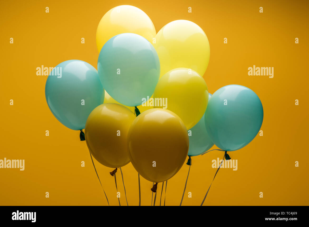 bright decorative blue and yellow balloons on yellow background Stock ...