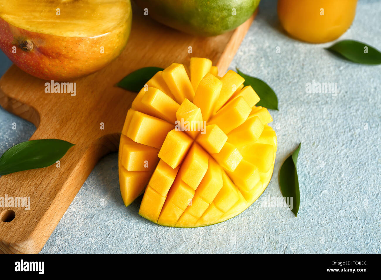 Tasty fresh mango with board on color background Stock Photo - Alamy