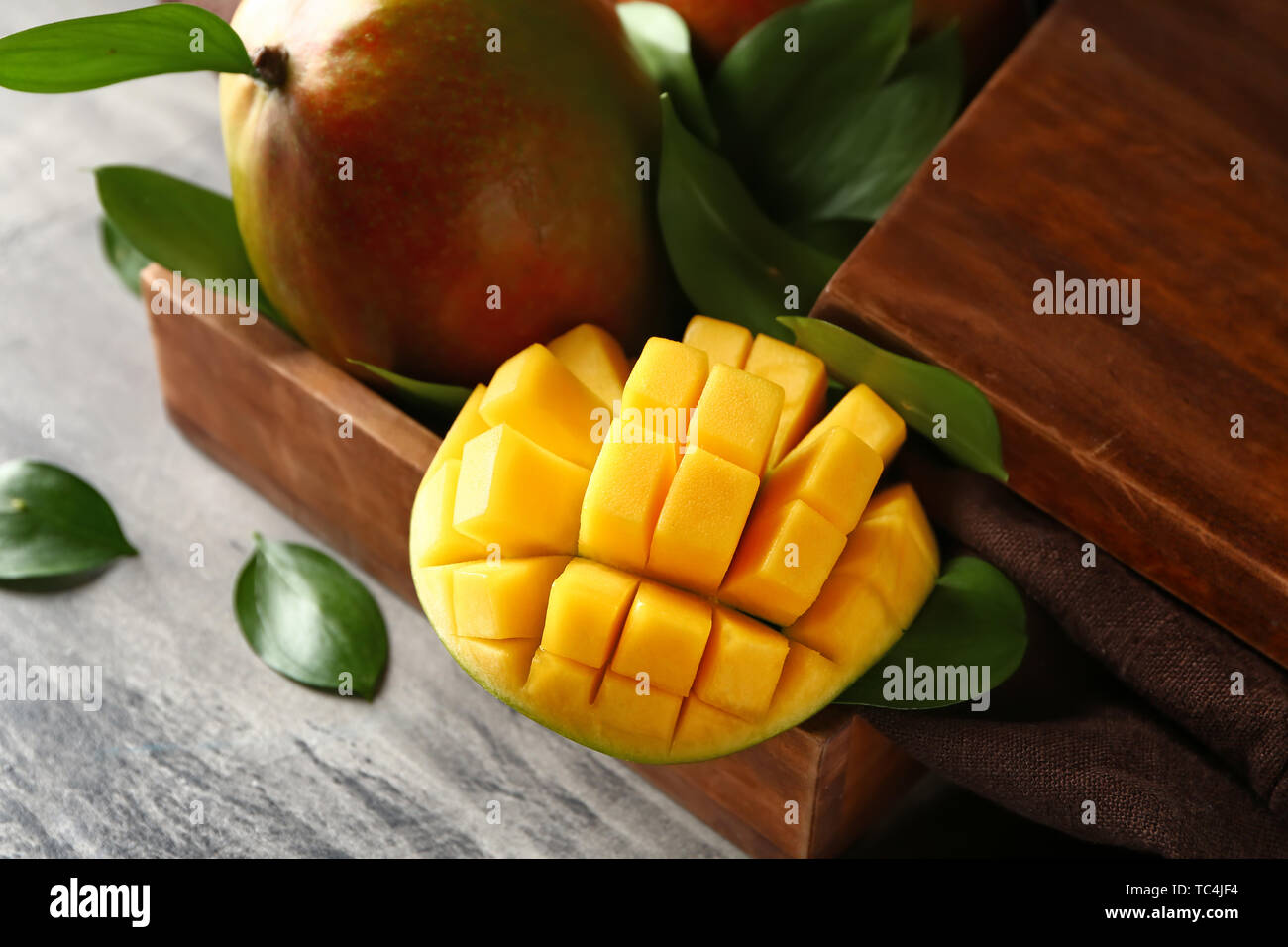 Wooden box with tasty sweet mango on grey table Stock Photo - Alamy