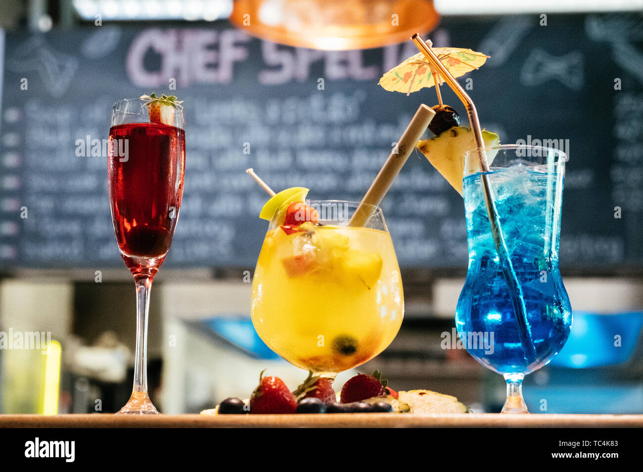 close up of a colorful fancy trendy cocktail garnished with fresh ...