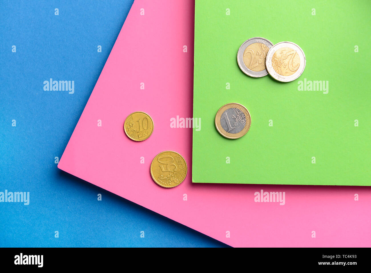 Paper sheets with coins on color background Stock Photo - Alamy
