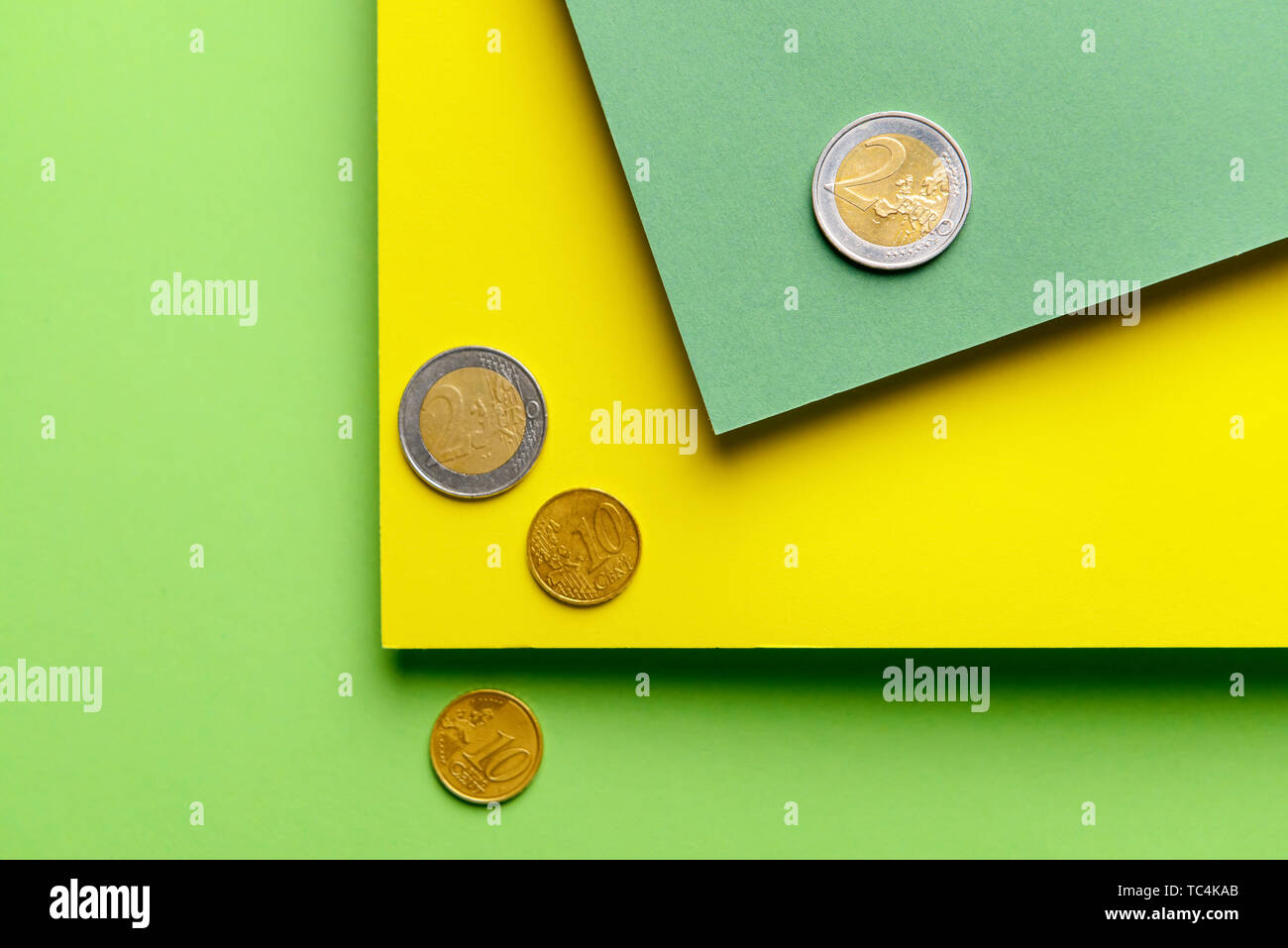 Paper sheets with coins on color background Stock Photo - Alamy