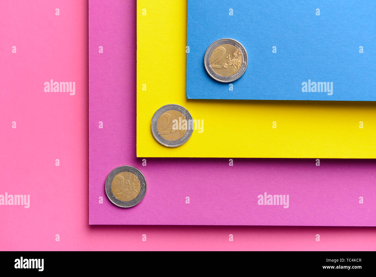 Paper sheets with coins on color background Stock Photo - Alamy