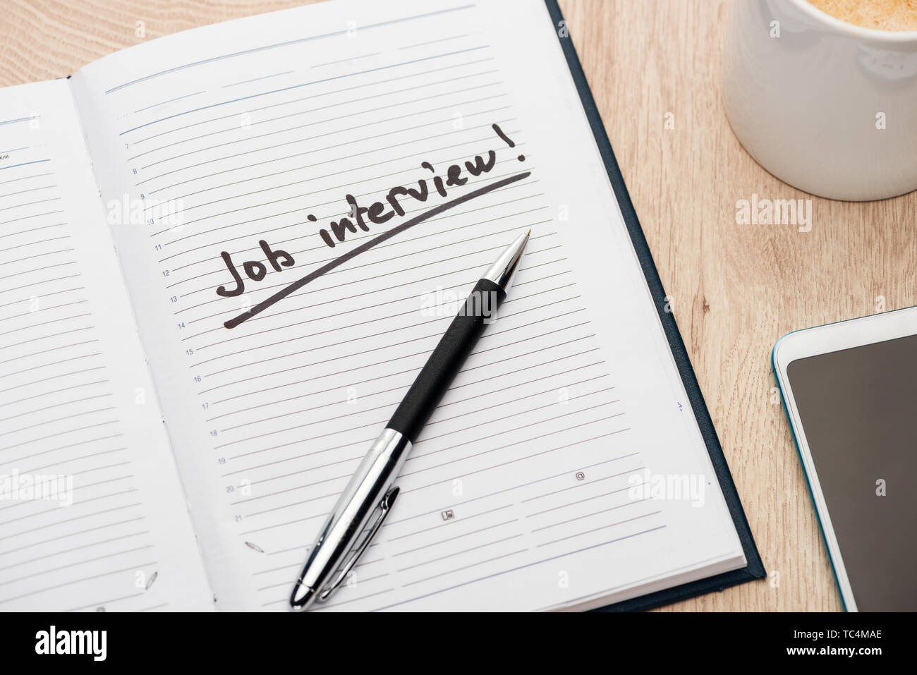 notebook with pen and job interview lettering on wooden table near ...