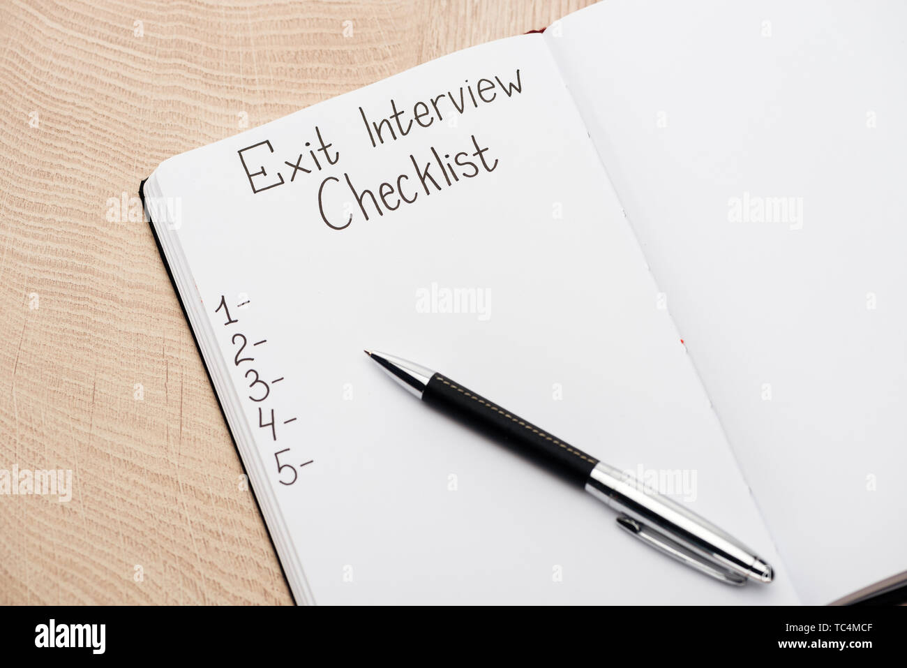 notebook with pen, exit interview checklist lettering and numbers on ...