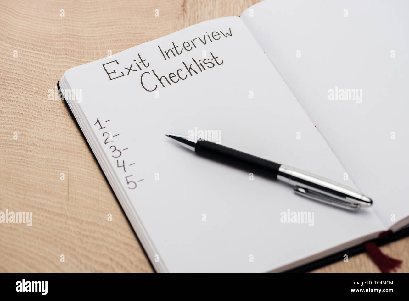 notebook with exit interview checklist lettering and numbers on wooden ...