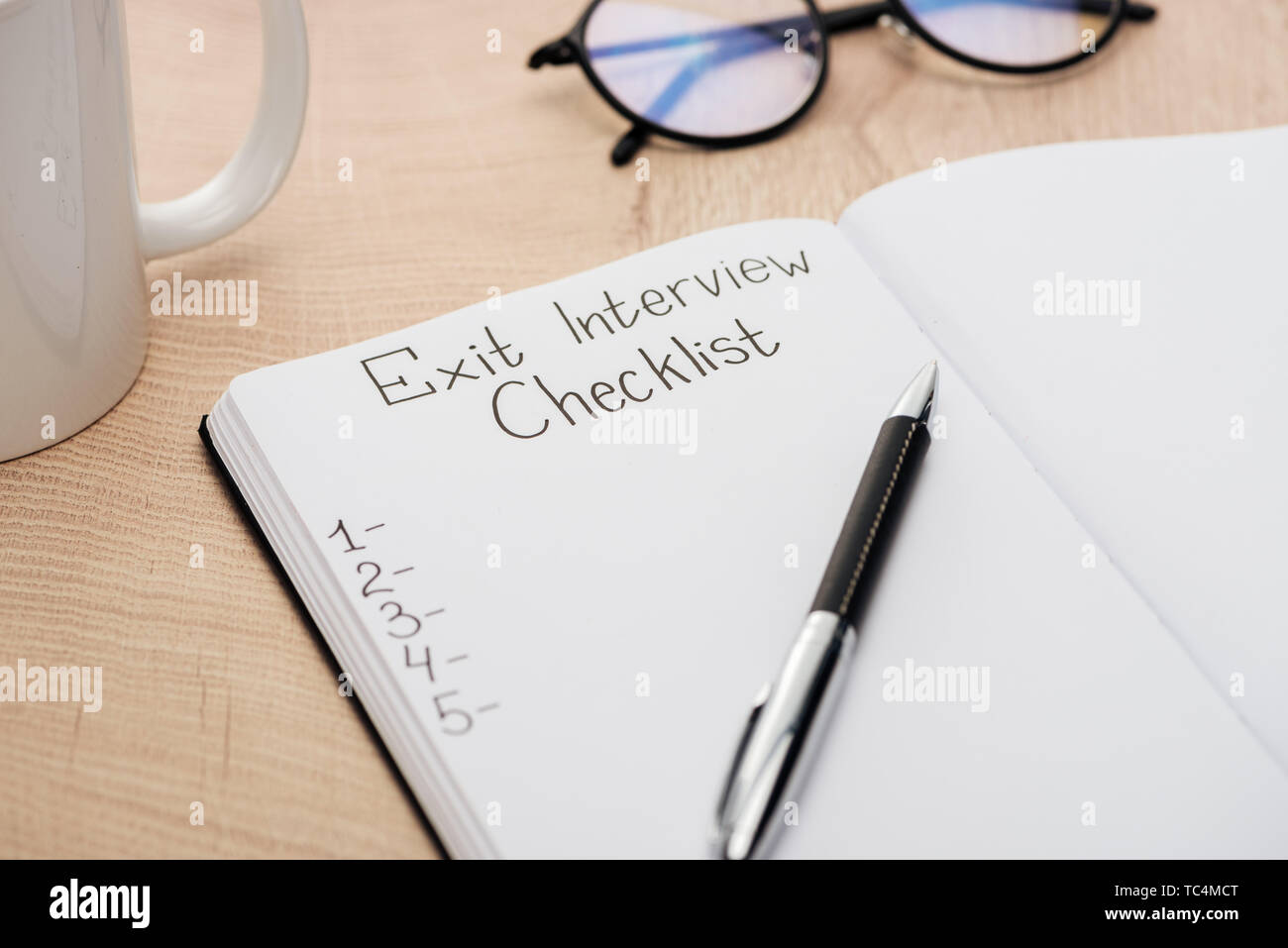 notebook with exit interview checklist lettering and numbers on wooden ...