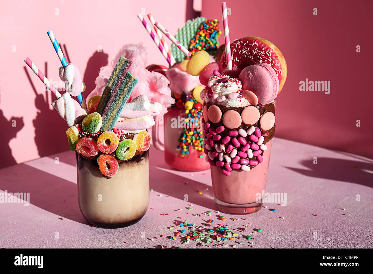 Different delicious freak shakes on color background Stock Photo - Alamy