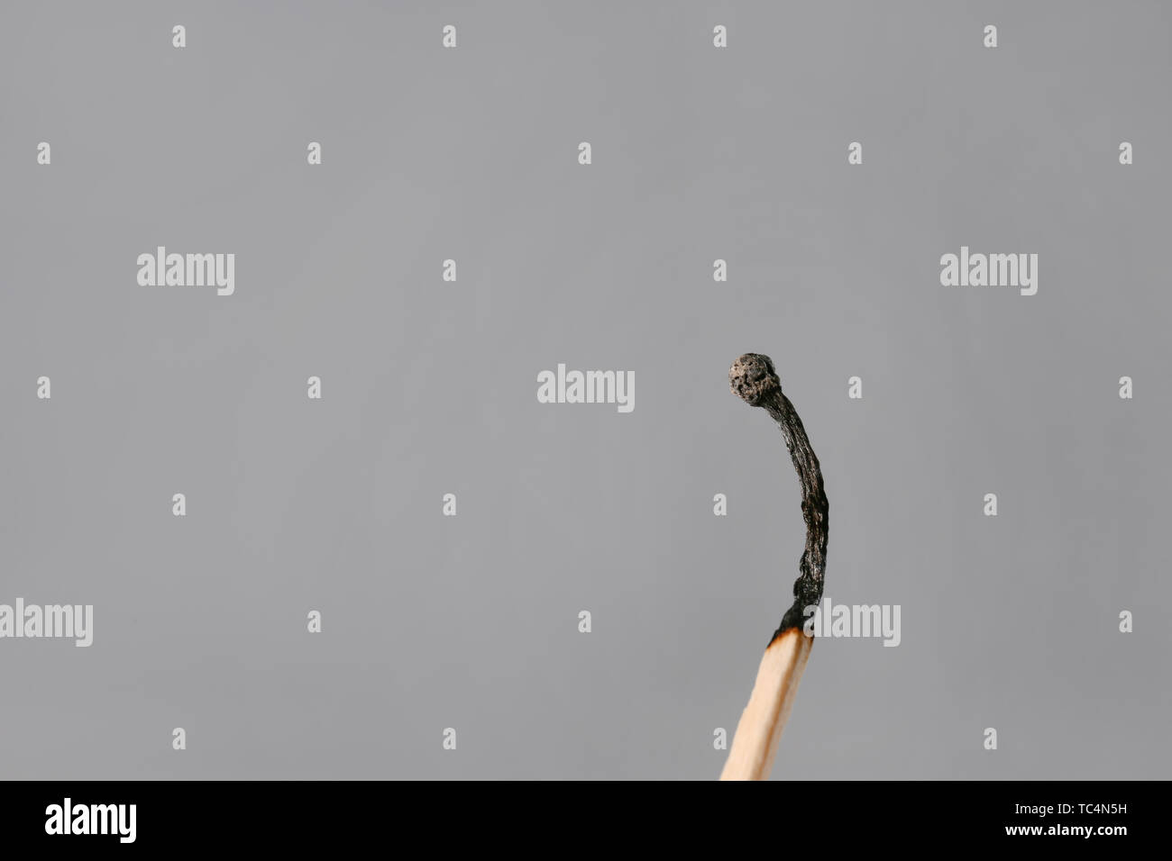 Burnt out match on grey background Stock Photo - Alamy