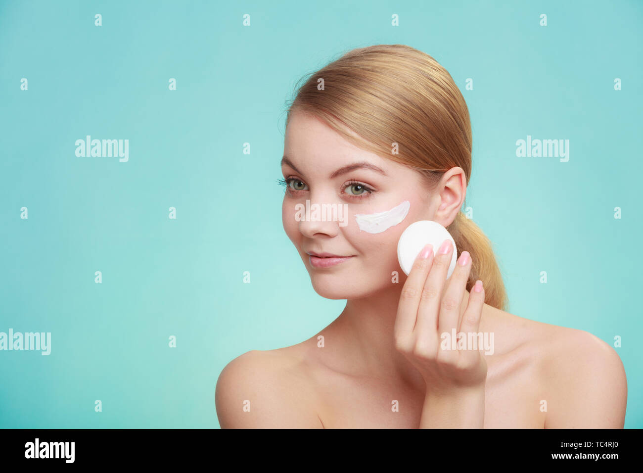 Woman removing makeup with cotton swab pad from face. Young girl taking ...