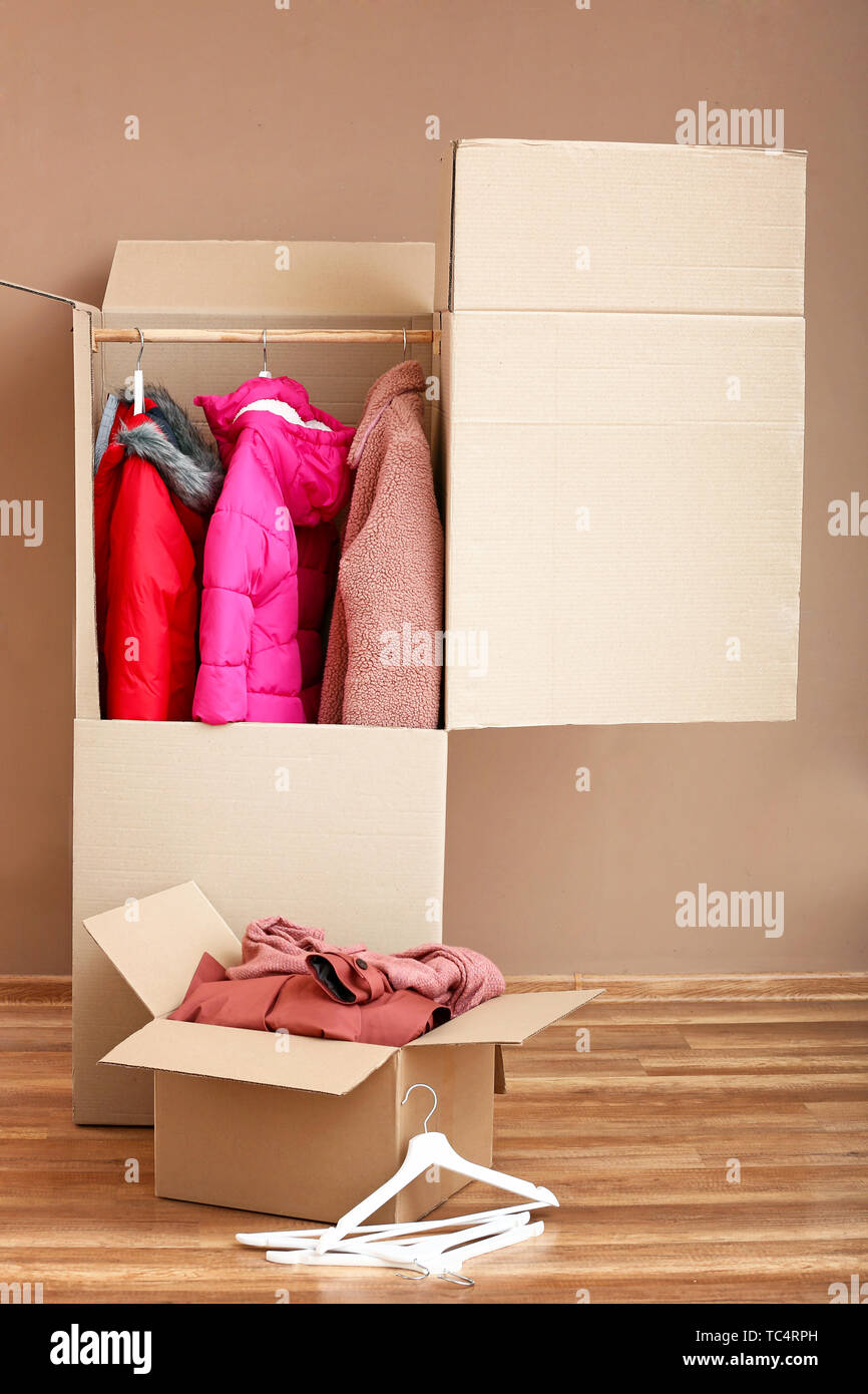 Wardrobe boxes with clothes near color wall Stock Photo - Alamy
