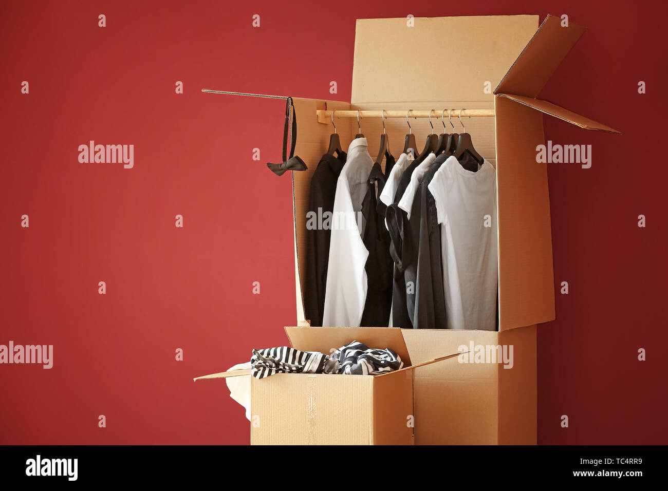 Wardrobe boxes with clothes on color background Stock Photo - Alamy