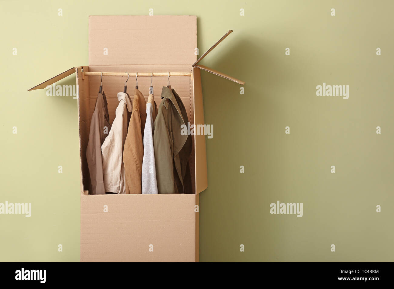 Wardrobe box with clothes on color background Stock Photo - Alamy