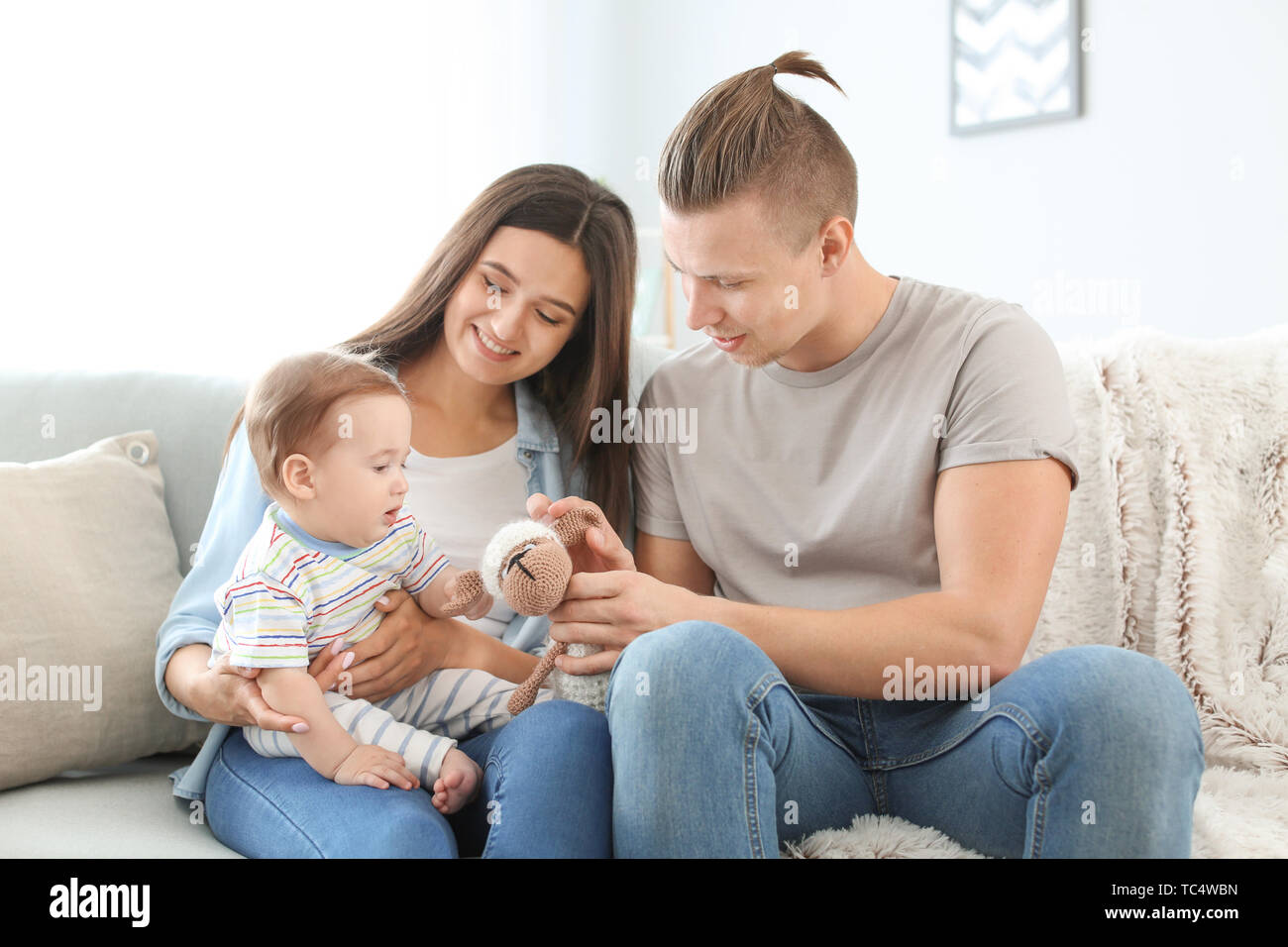 Happy parents with cute little baby at home Stock Photo - Alamy