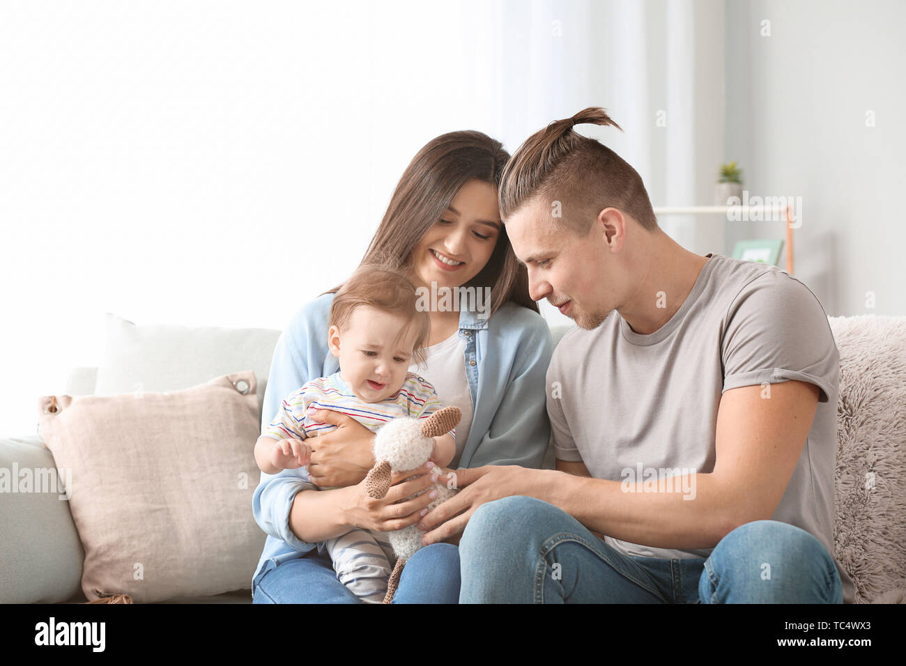 Happy parents with cute little baby at home Stock Photo - Alamy
