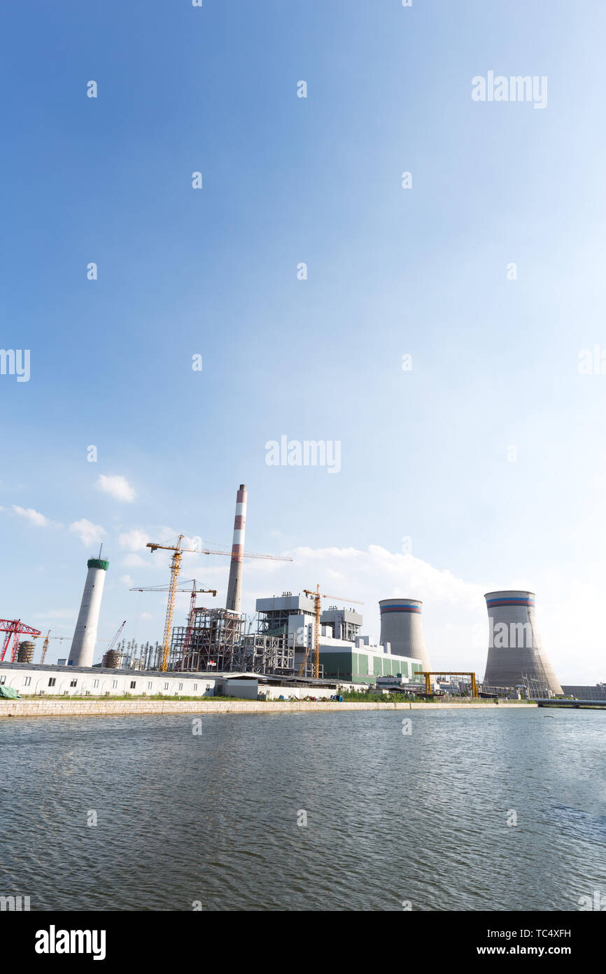modern power plant near river in blue sky Stock Photo - Alamy