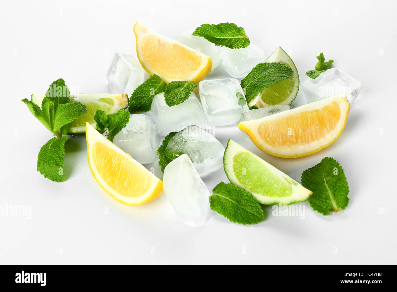 Ice cubes, fresh cut citrus fruits and mint leaves on white background ...