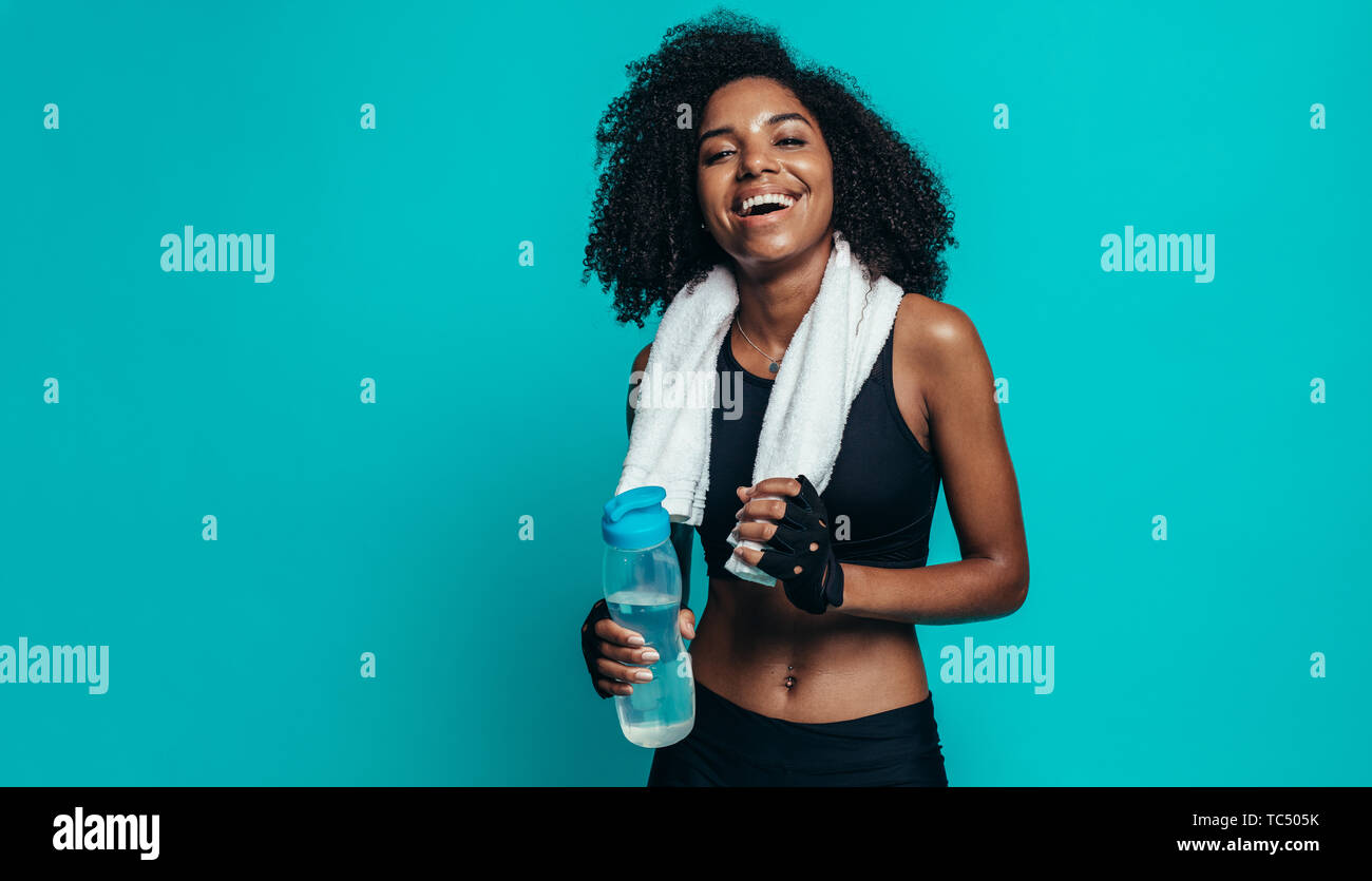 Happy young woman resting after workout on blue background. Healthy ...