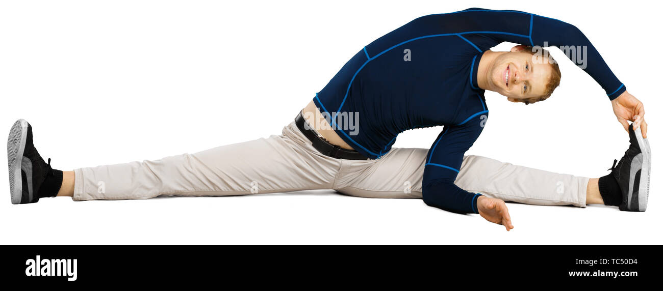 Flexible sporty young man doing stretching exercises isolated on white ...