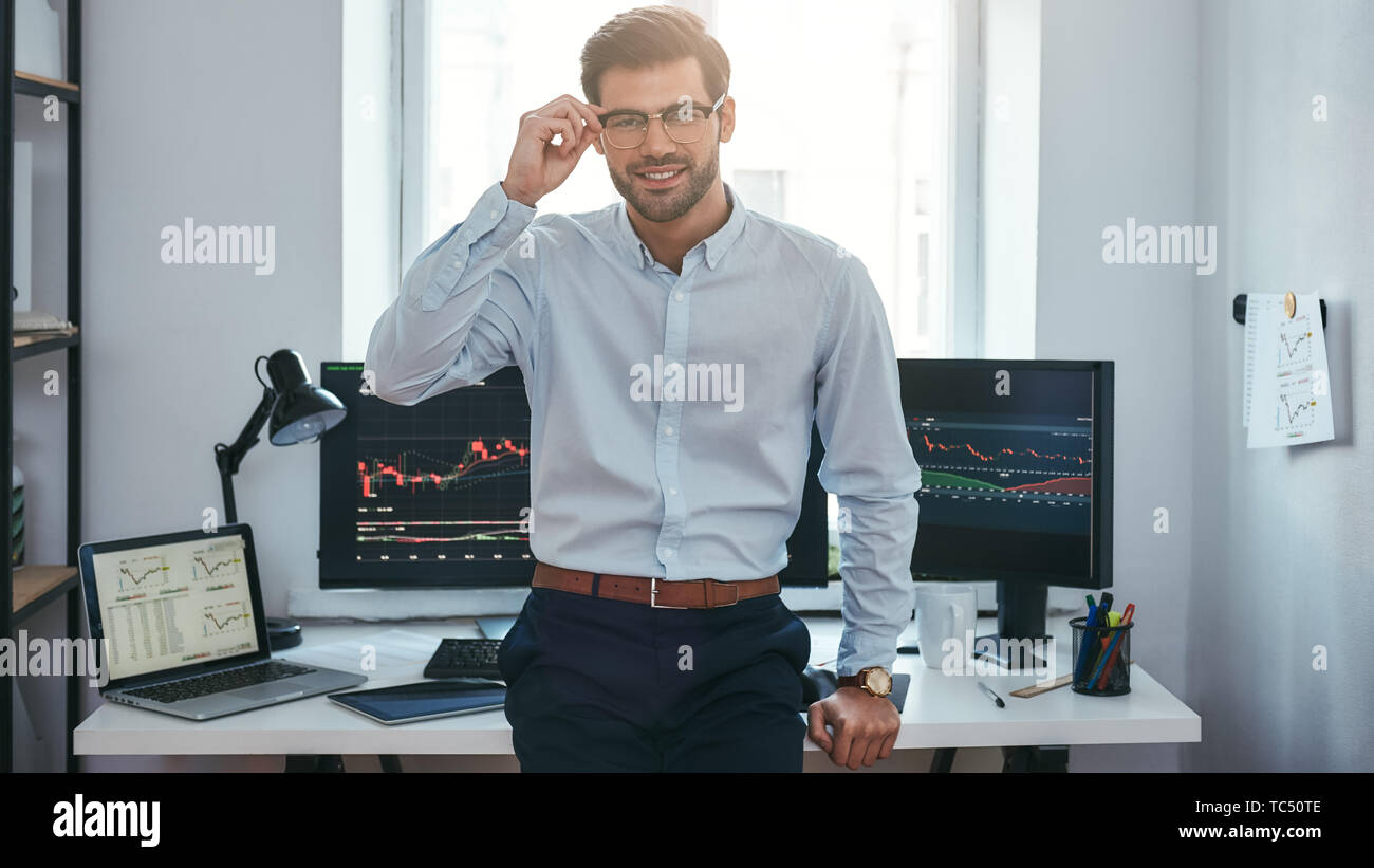 Successful trader. Modern young businessman in formal clothes adjusting ...