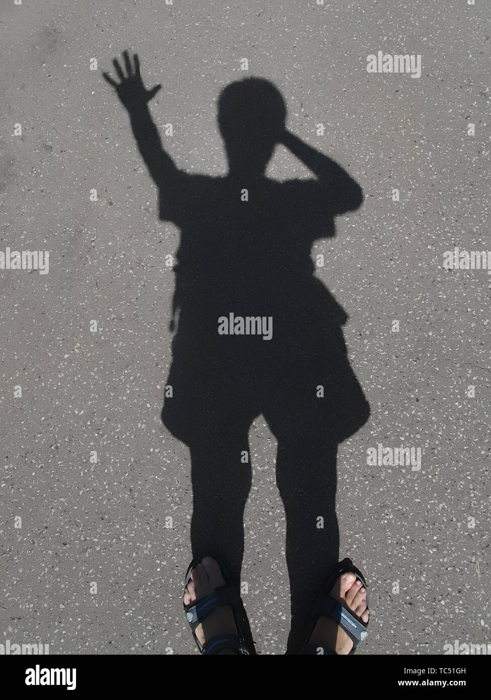 human shadow with a raised hand on the pavement Stock Photo - Alamy