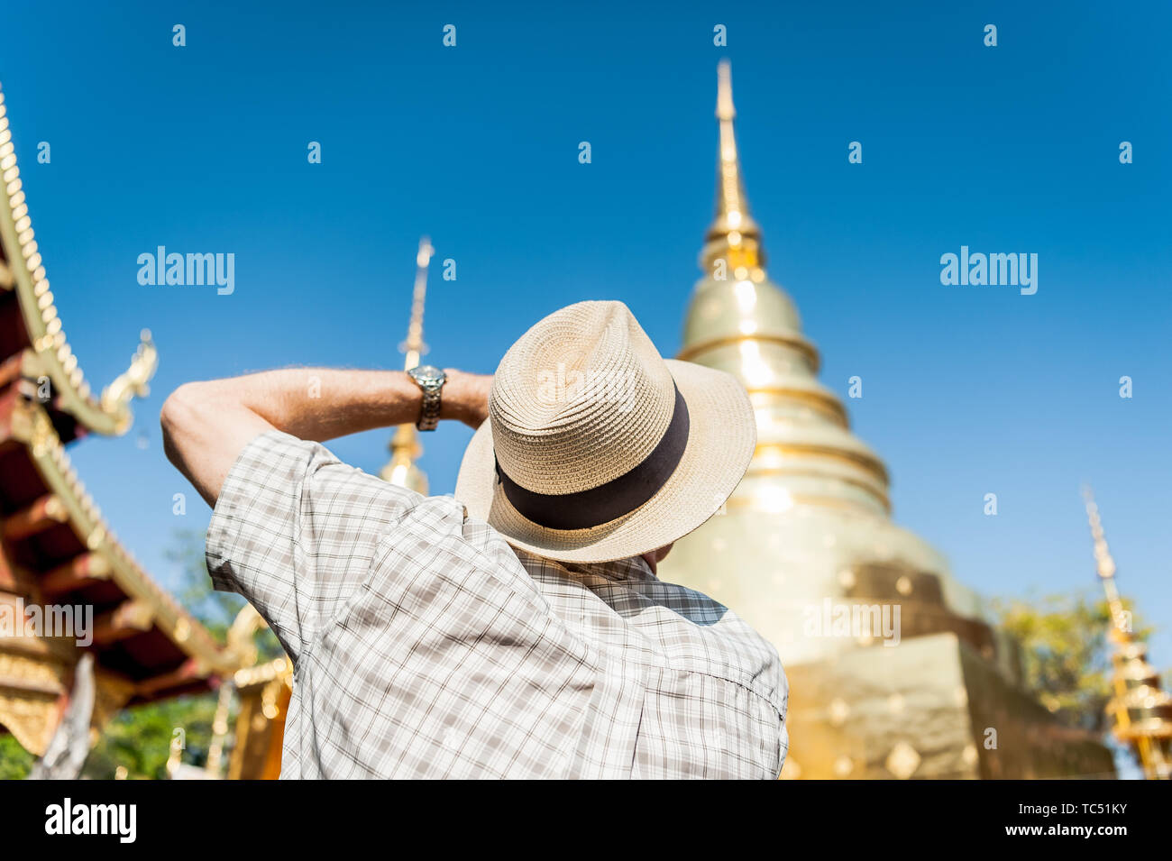 A tourist takes a photo of the ornate temple design at the famous Wat ...