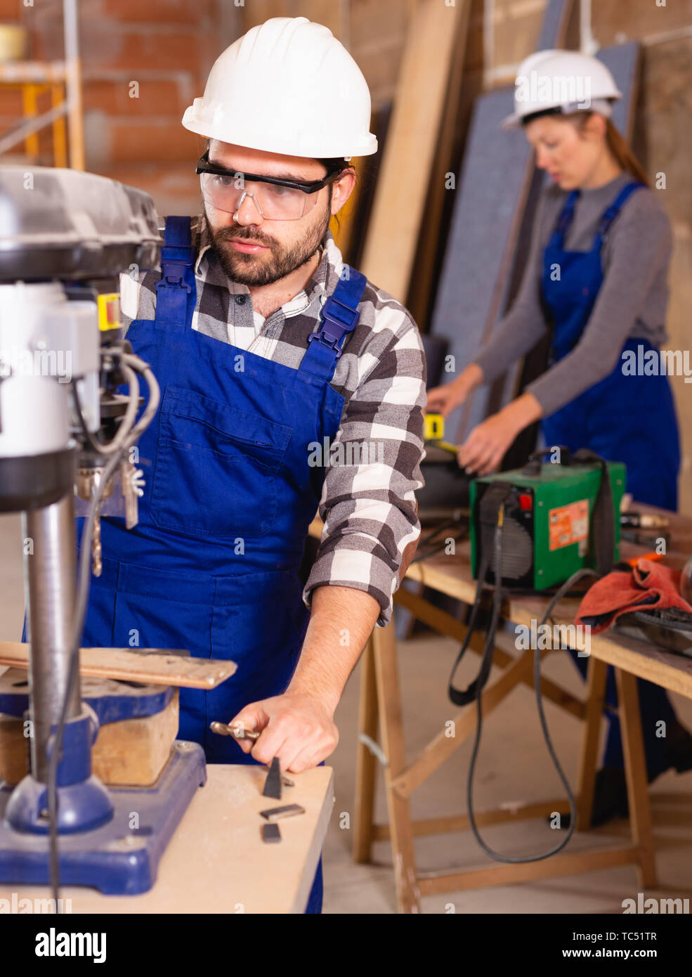 Man is worker behind drilling machine Stock Photo - Alamy
