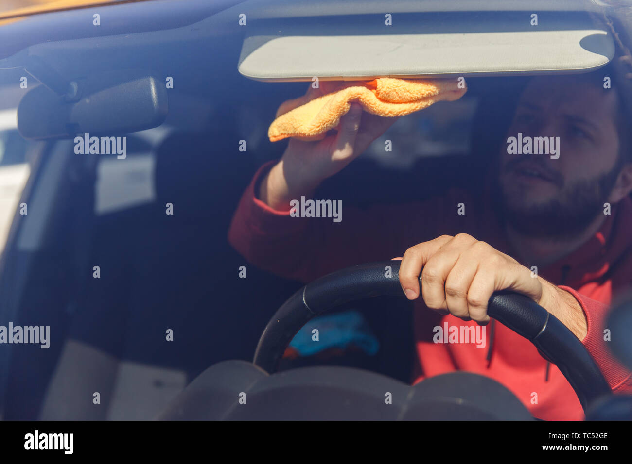 Photo of man with an orange rag washing windshield Stock Photo - Alamy
