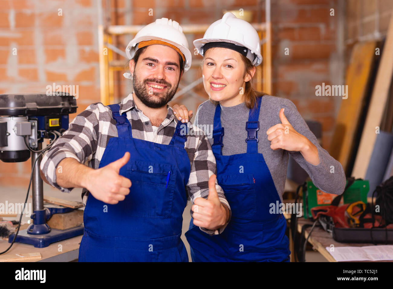 Two professional builders with thumbs up Stock Photo - Alamy