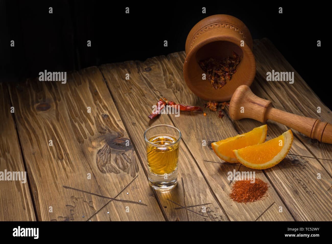 Mezcal shot mexican drink with orange slices, chili and worm salt in ...