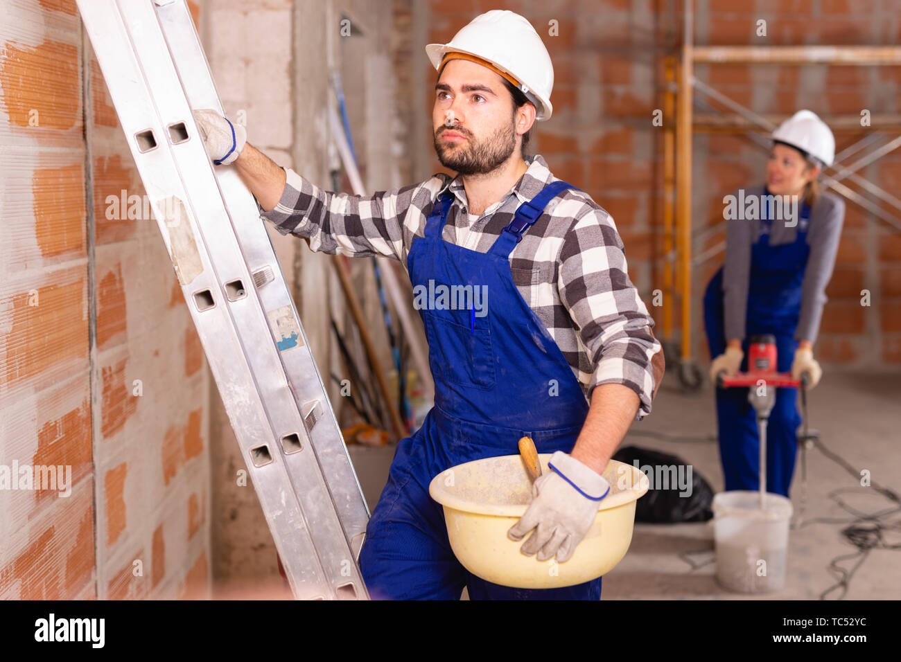 Portrait of builder in process of finishing work in cottage Stock Photo ...