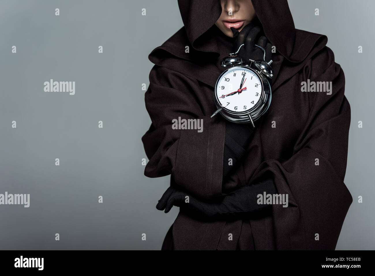 cropped view of woman in death costume holding alarm clock isolated on ...