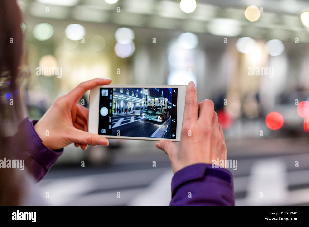 Hand and mobile phone on city road Stock Photo - Alamy
