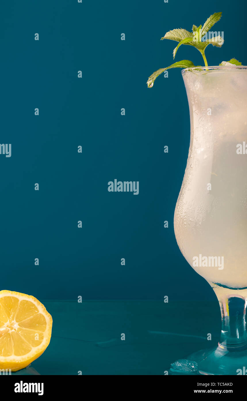 Lemonade glass with ice and mint leaves. Water droplets dripping on the ...