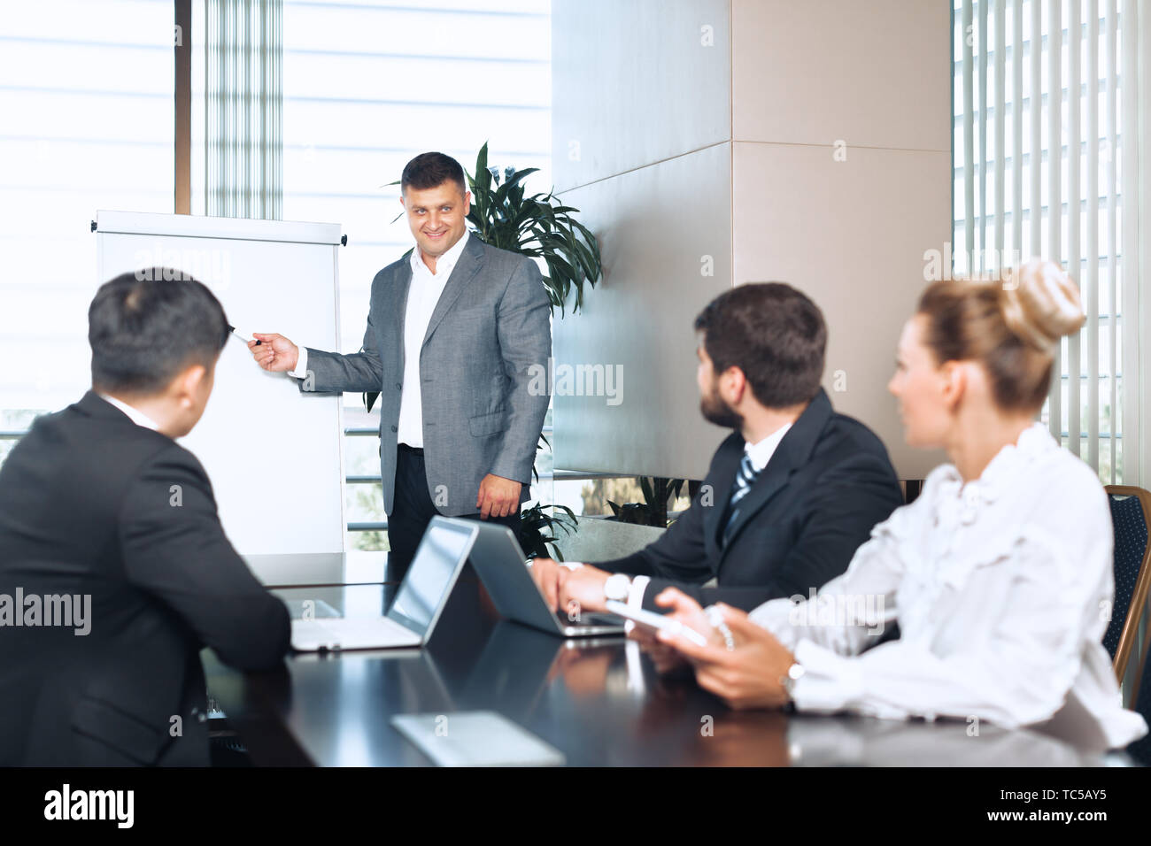 Businessman sitting around boardroom table hi-res stock photography and ...